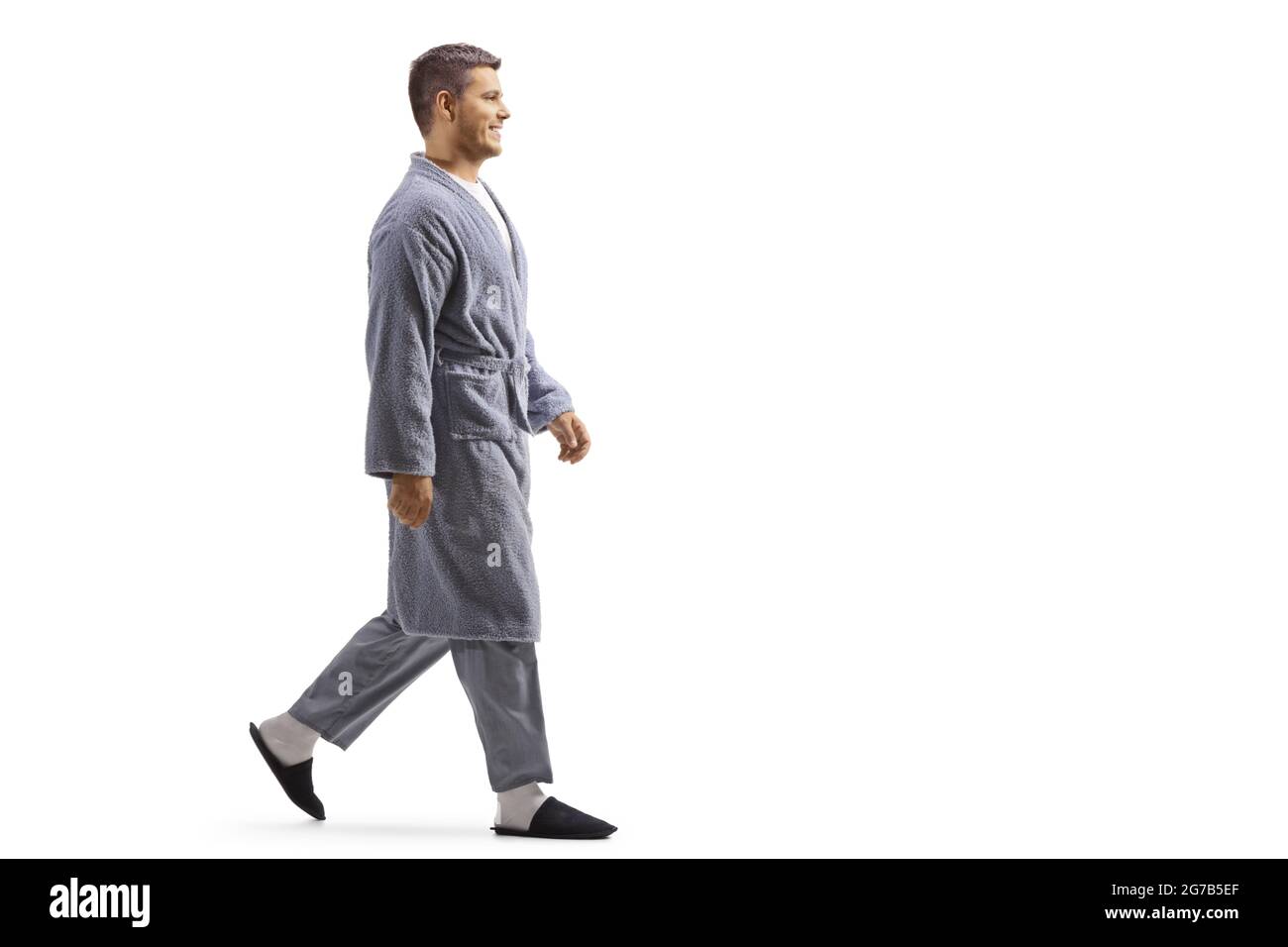 Full length profile shot of a young man wearing a robe and walking ...