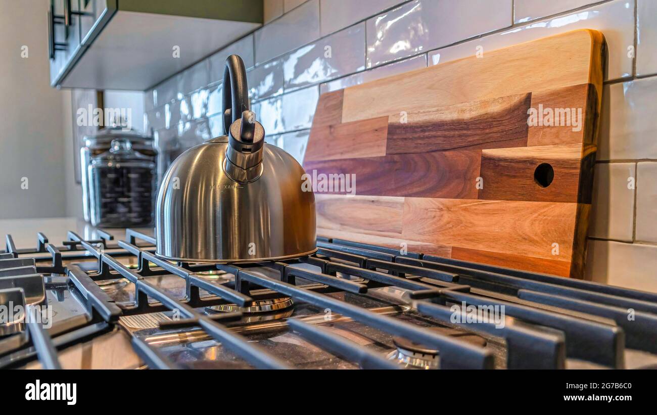 Pano Cooktop with kettle over burner and cast iron grate inside a ...