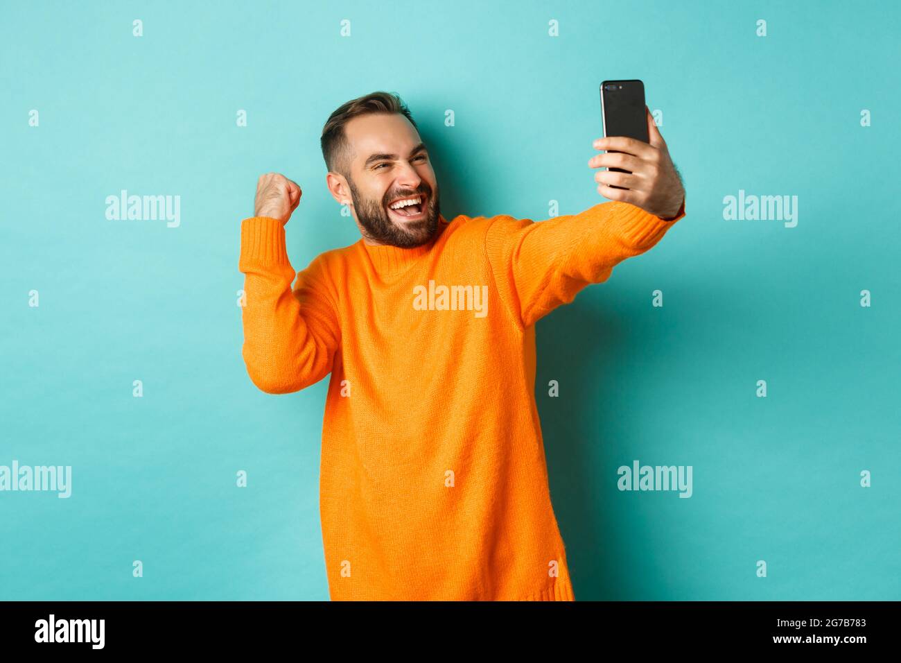 Handsome man video calling, looking happy and rejoicing of good news ...