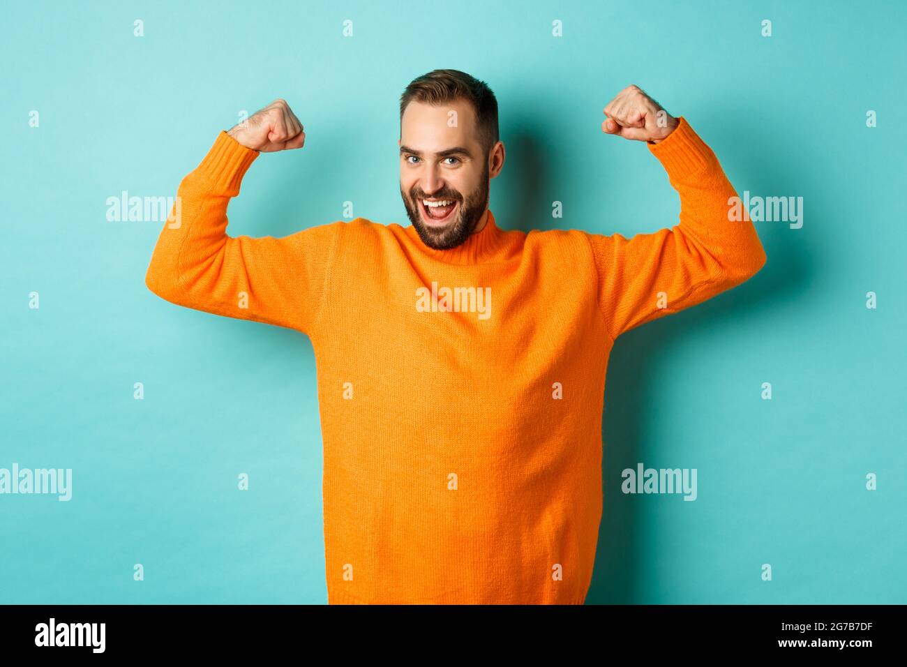 Young and strong man looking confident, flex biceps and show-off muscle ...