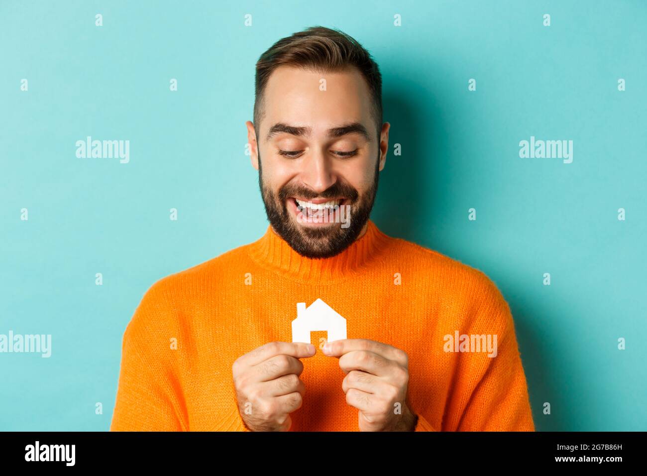 Real estate concept. Happy young man searching for home rent, holding ...