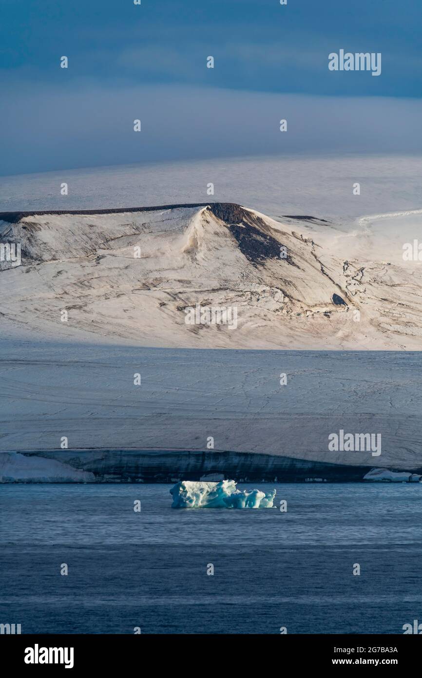 Iceberg floating before the flat table mountains covered with ice ...