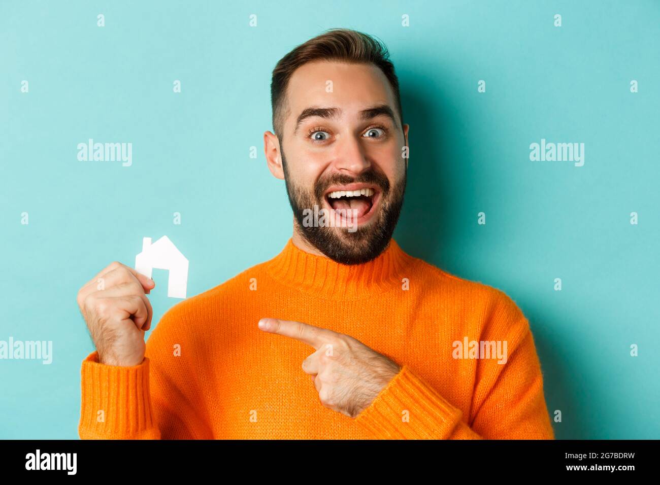 Real estate. Excited bearded man pointing at small paper house maket ...