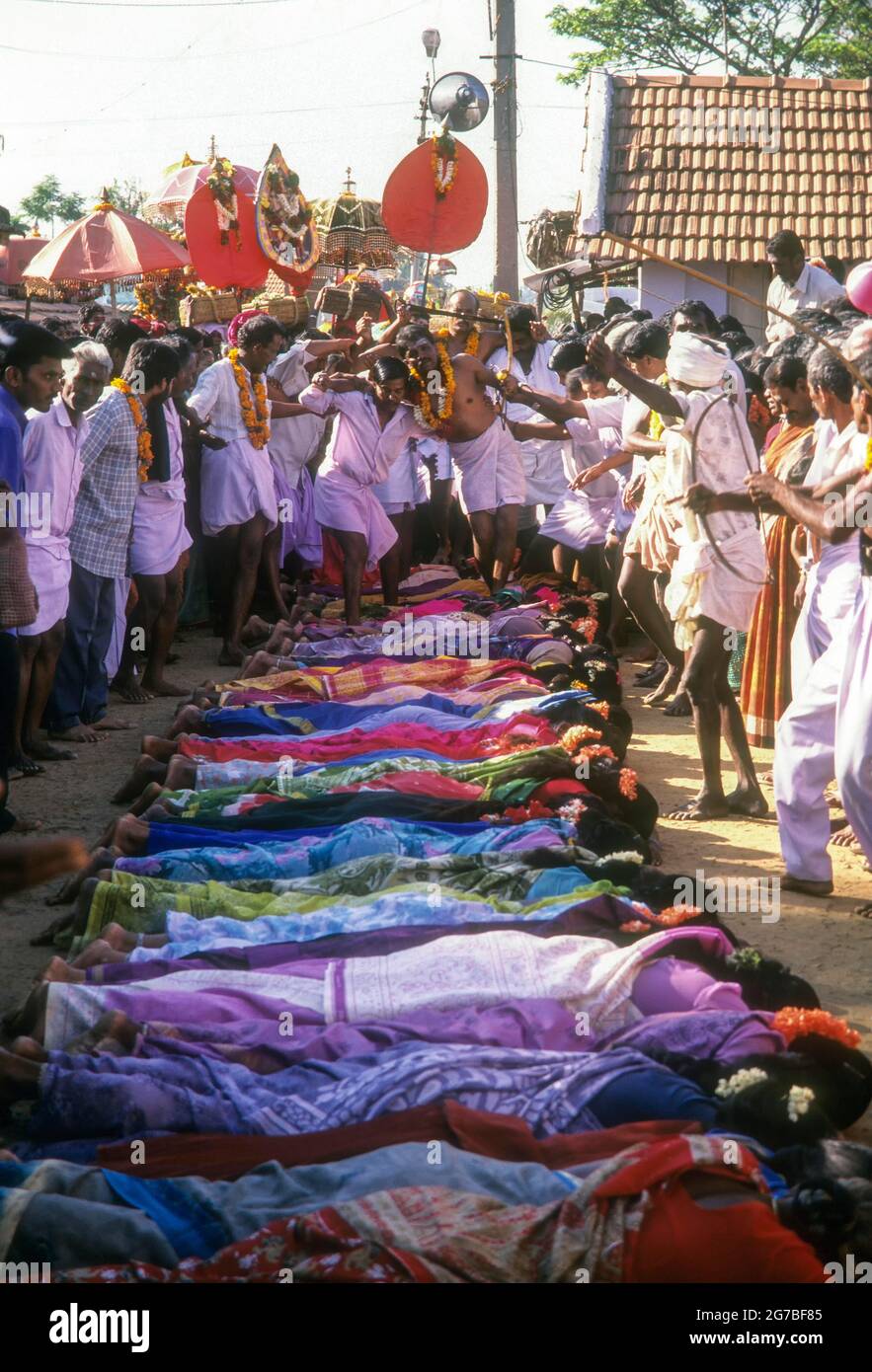Poojari or priest walking on women in Mahasivaratri festival at ...