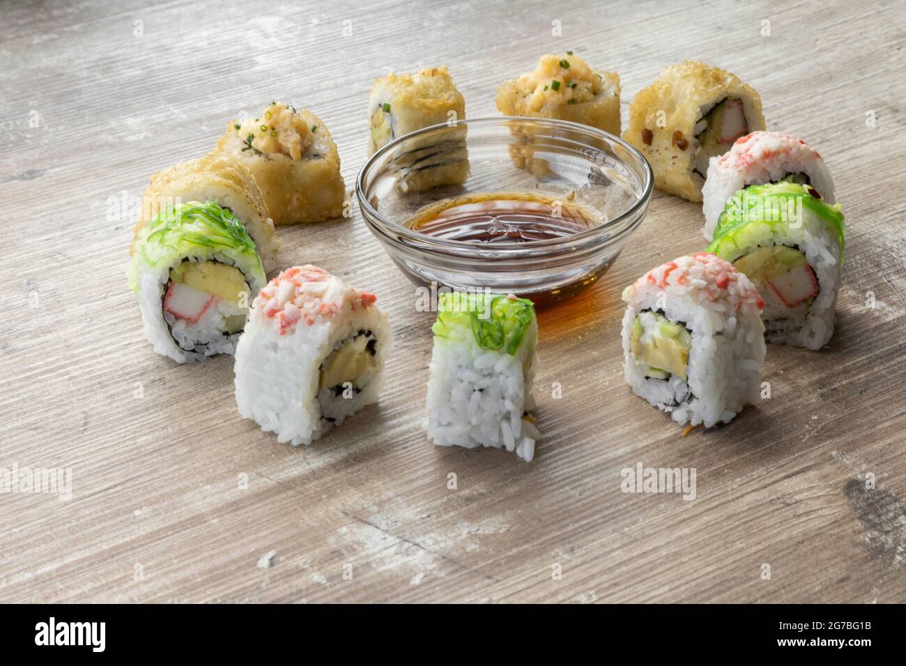 on a textured wooden table sushi rolls in the shape of a circle around ...