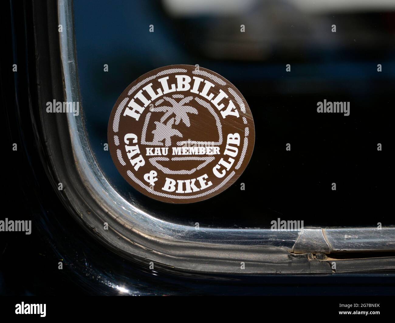 A Hillbilly Car and Bike Club decal on the window of a vintage car on ...