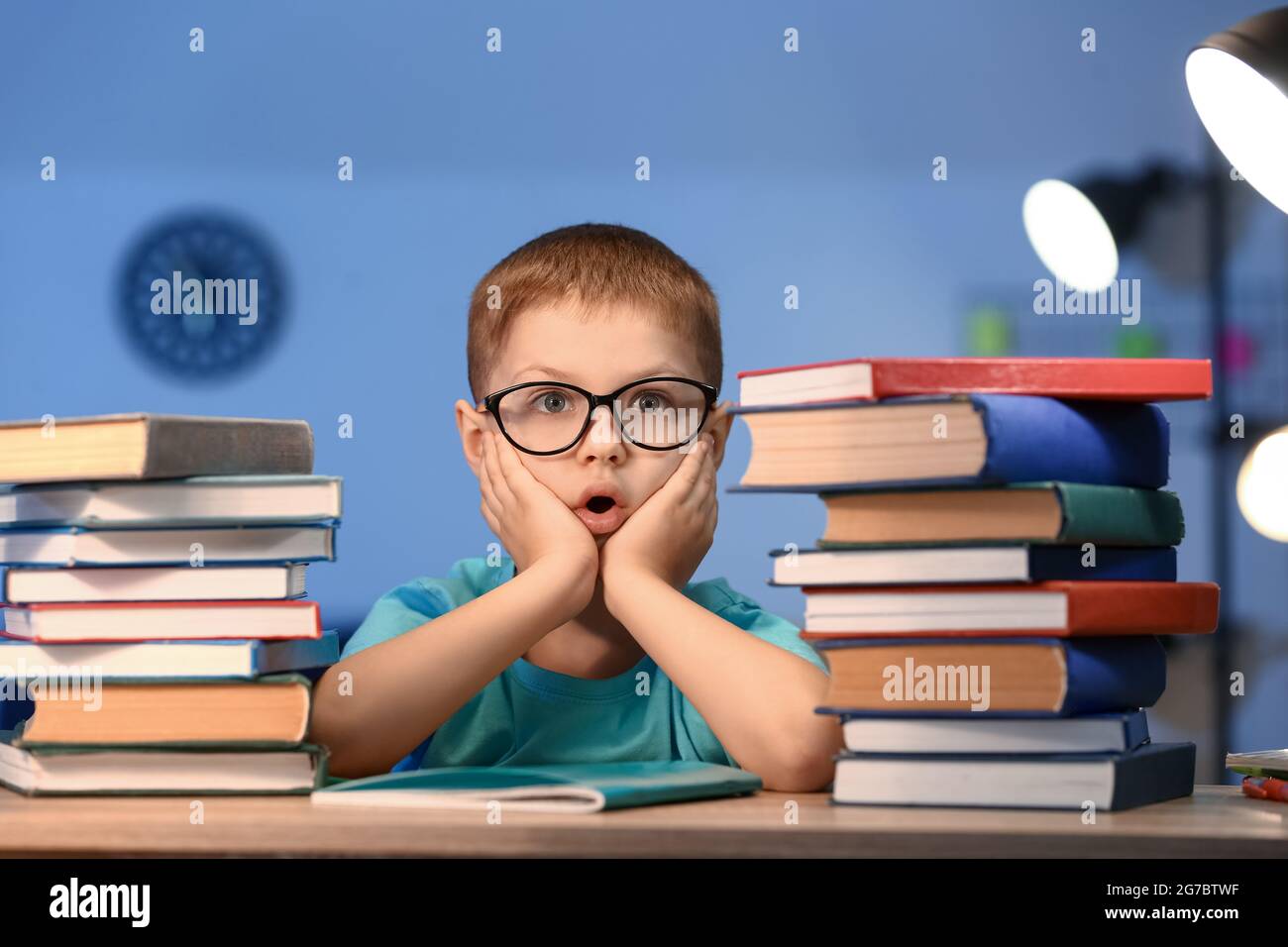 Shocked little boy with books at home late in evening Stock Photo - Alamy