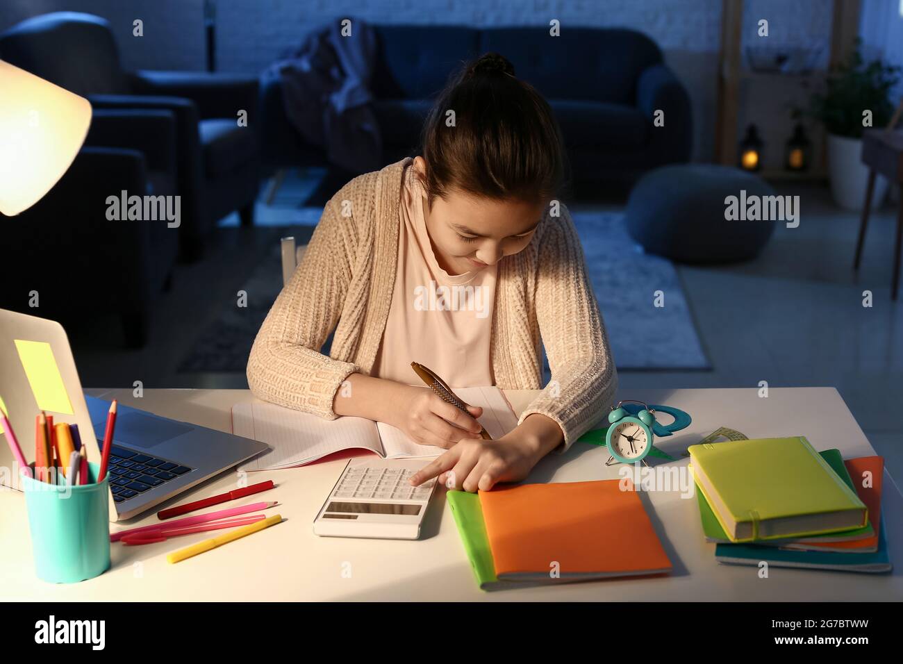 Little girl doing homework at home late in evening Stock Photo - Alamy