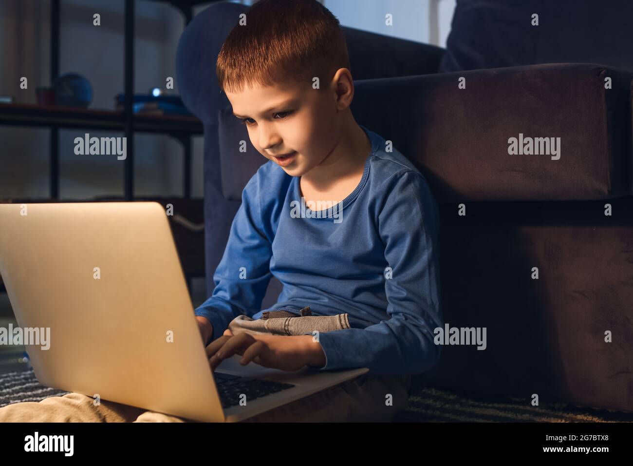 Little boy doing homework online at home late in evening Stock Photo ...