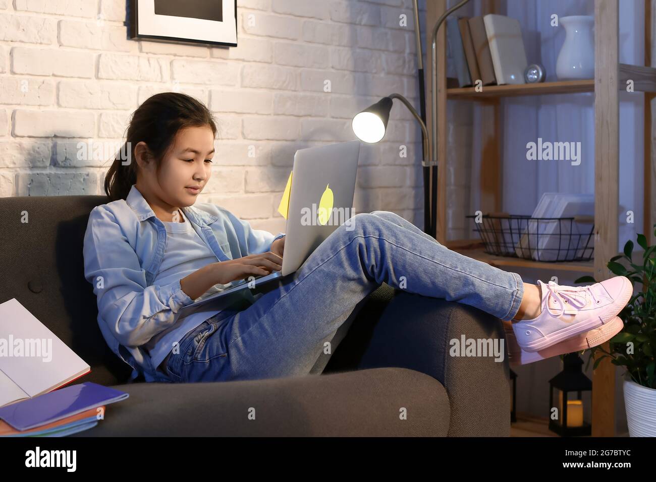 Little girl doing homework online at home late in evening Stock Photo ...