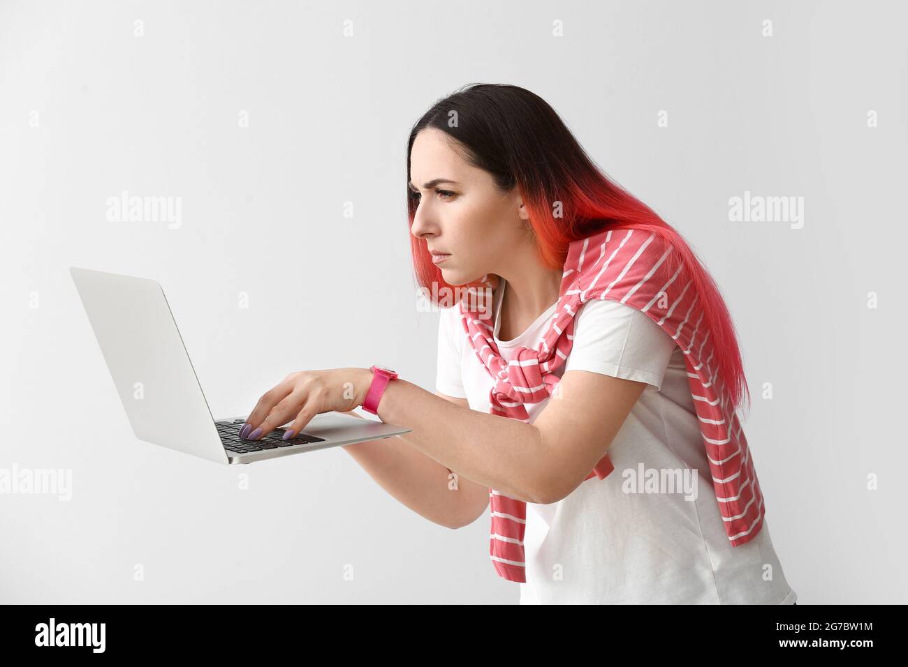 Female programmer using laptop on light background Stock Photo - Alamy