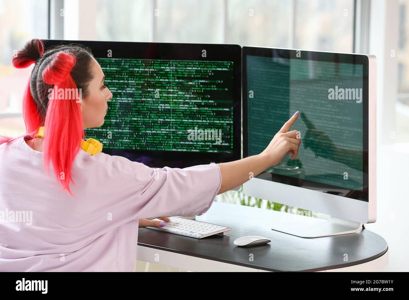 Female programmer pointing at computer screen in office Stock Photo - Alamy