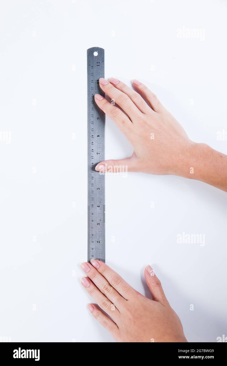a man's hands holding stainless steel ruler to measure something Stock ...