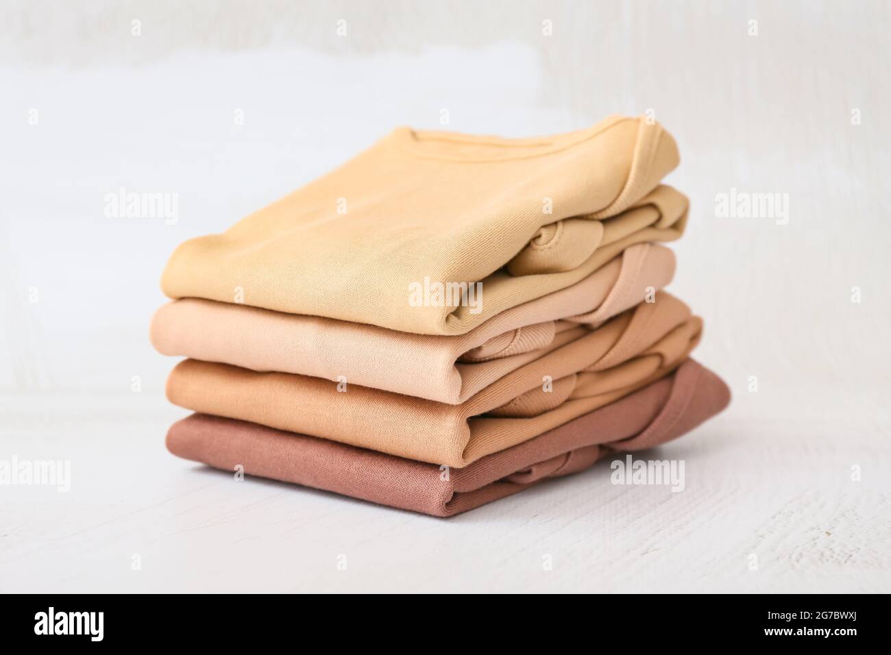 Stack of baby clothes on light background Stock Photo - Alamy