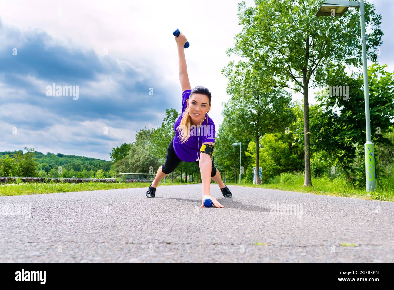 Urban sports - young woman is doing warming up before running in the ...