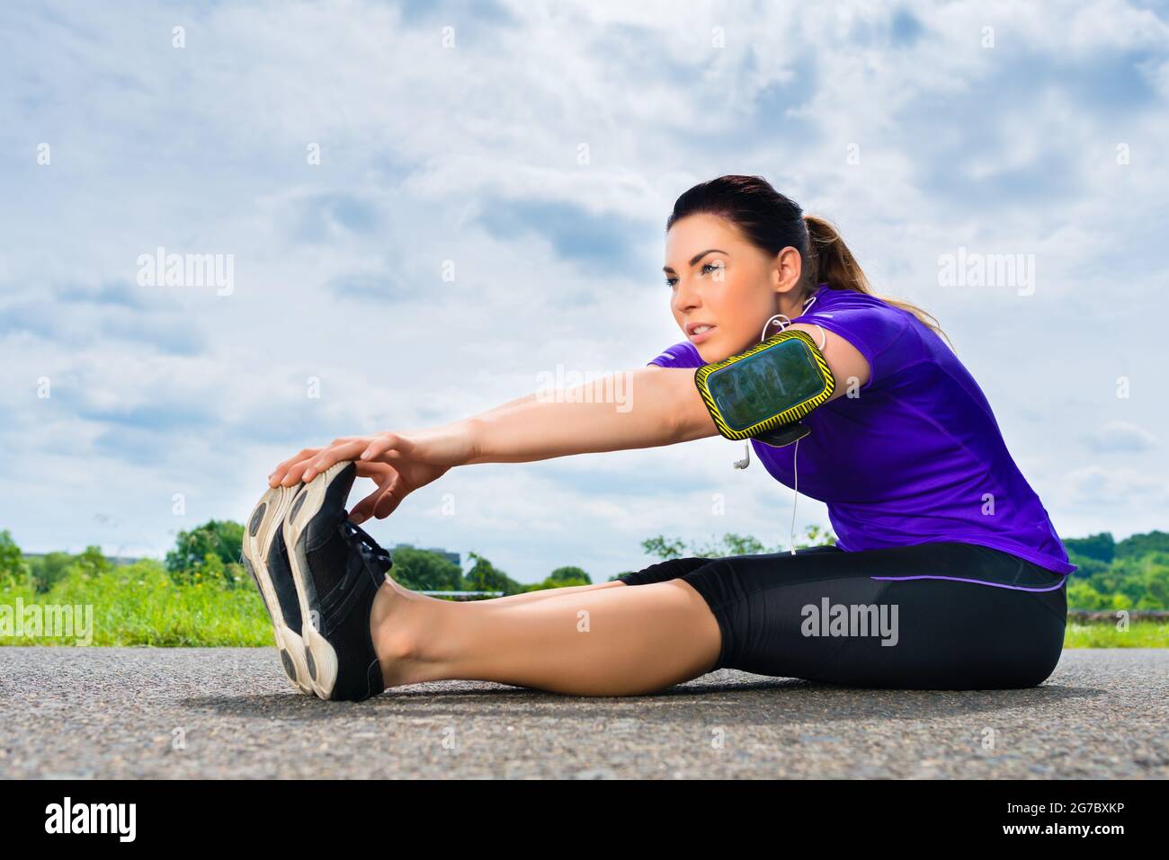 Urban sports - young woman is doing warming up before running in the ...
