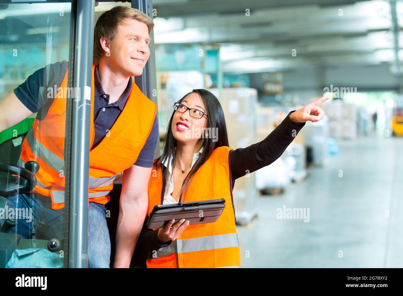 Logistics Teamwork - forklift driver, Worker or warehouseman and his ...
