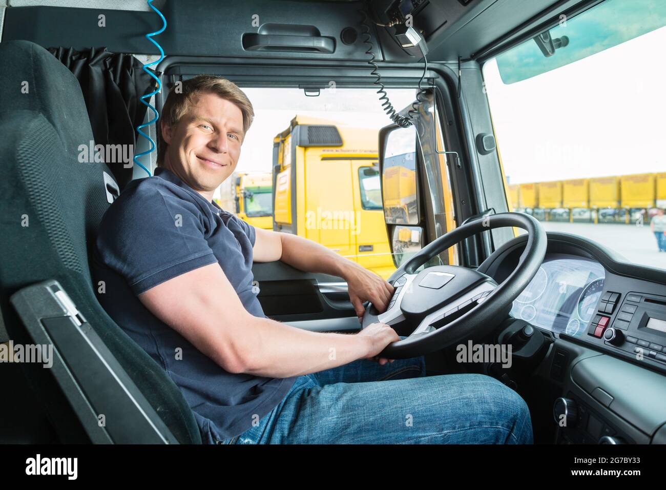 Logistics - proud driver or forwarder in drivers cap of truck and ...