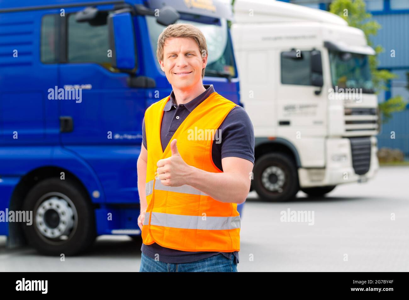 Logistics - proud driver or forwarder in front of trucks and trailers ...