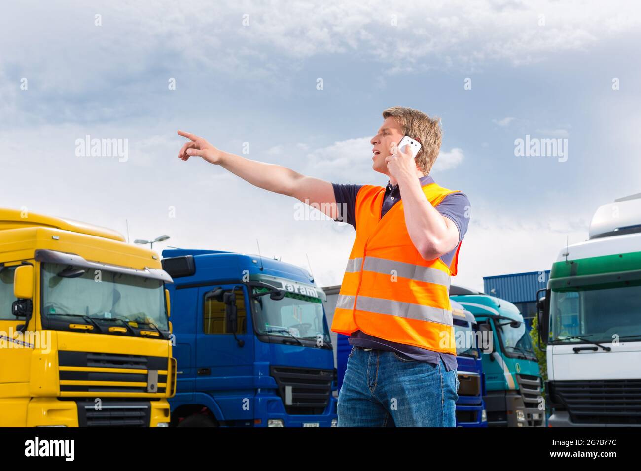 Logistics - proud driver or forwarder with mobile phone in front of ...
