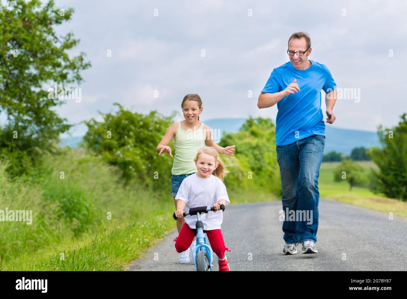 Family activity - Little girl and their father or dad running on street ...