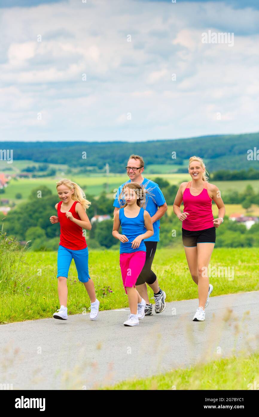 Family - mother, father and four children - doing jogging or outdoor ...