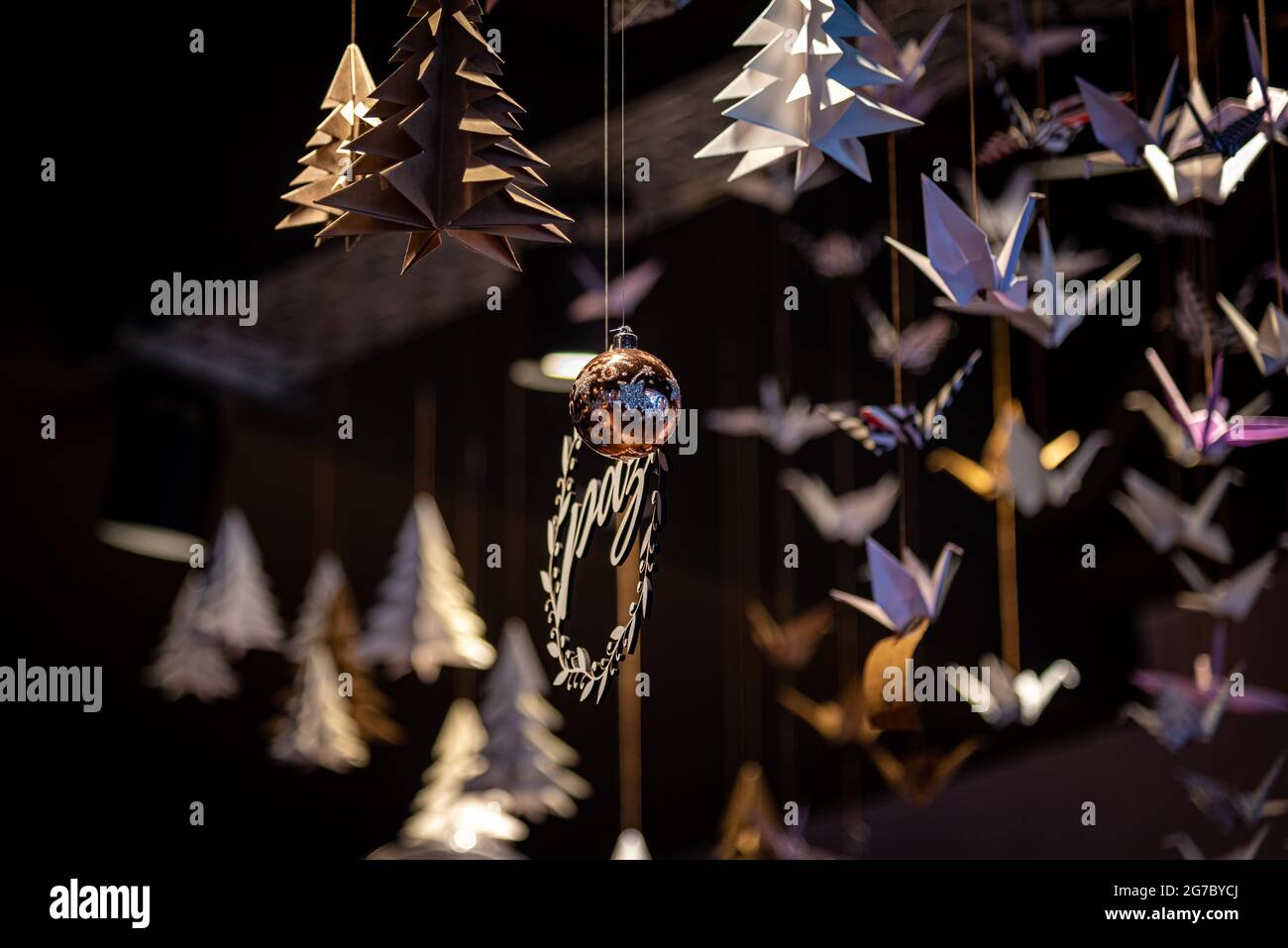 Lots of origami swans hanging from the roof, seen from underneath in a ...