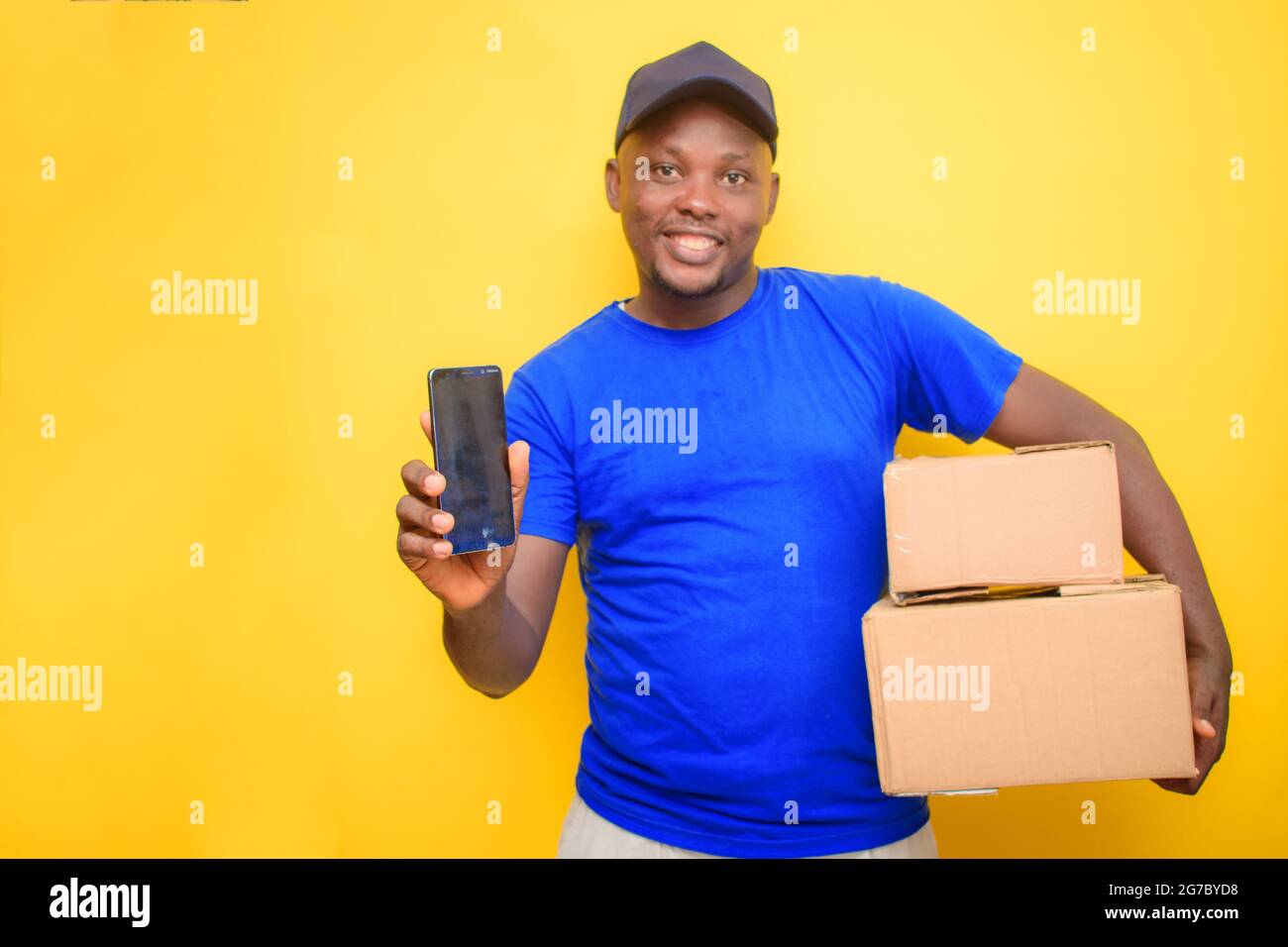 An African dispatch man with face cap, carrying delivery boxes and ...