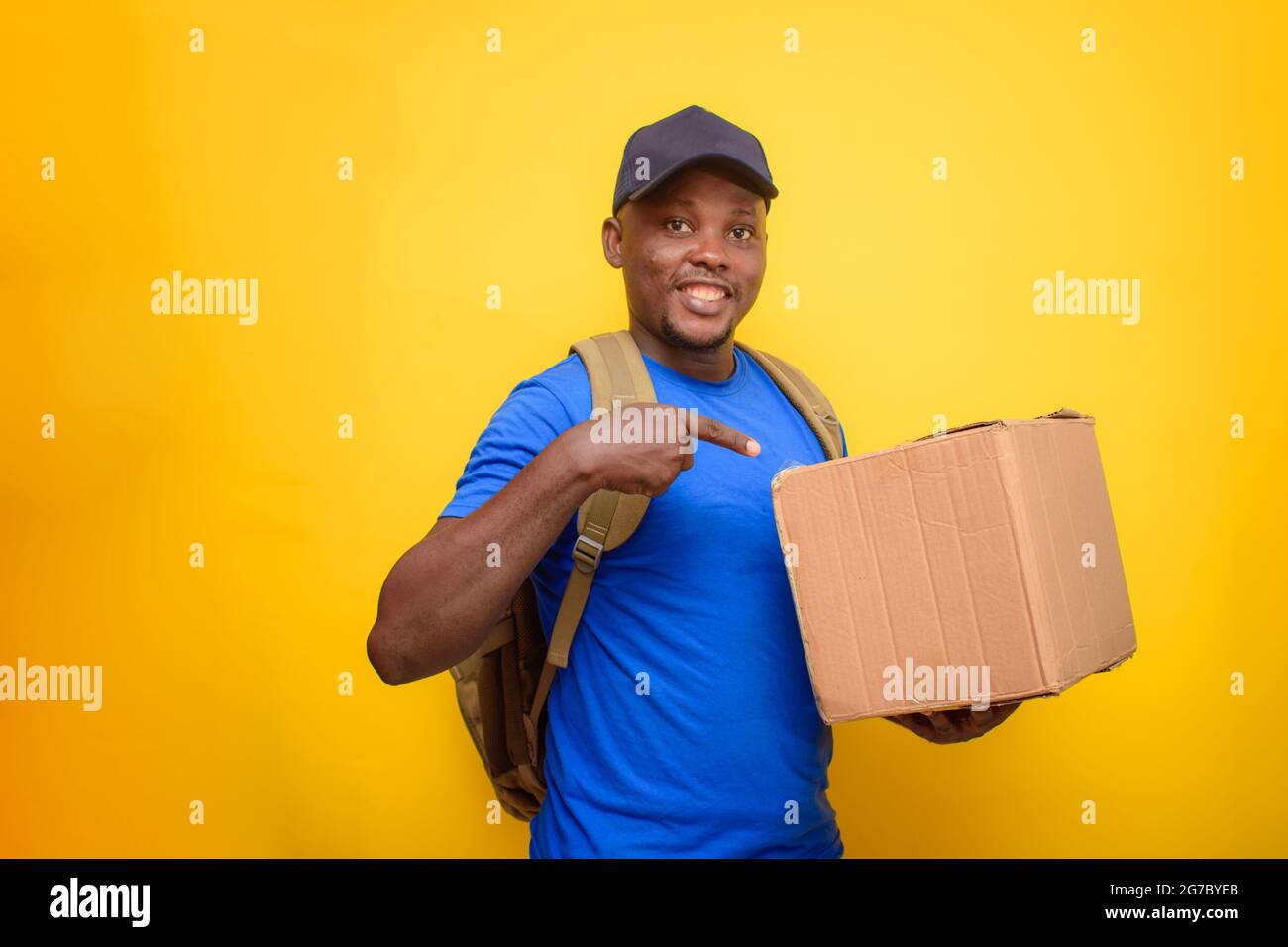 An African dispatch man with face cap and pointing to the boxes he is ...