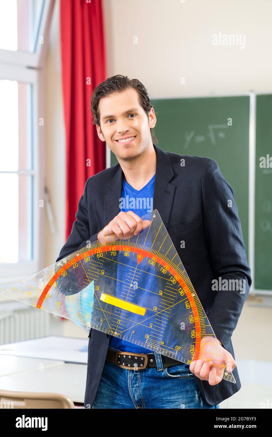 Teacher or docent in school holding a geometry triangle in front of a ...