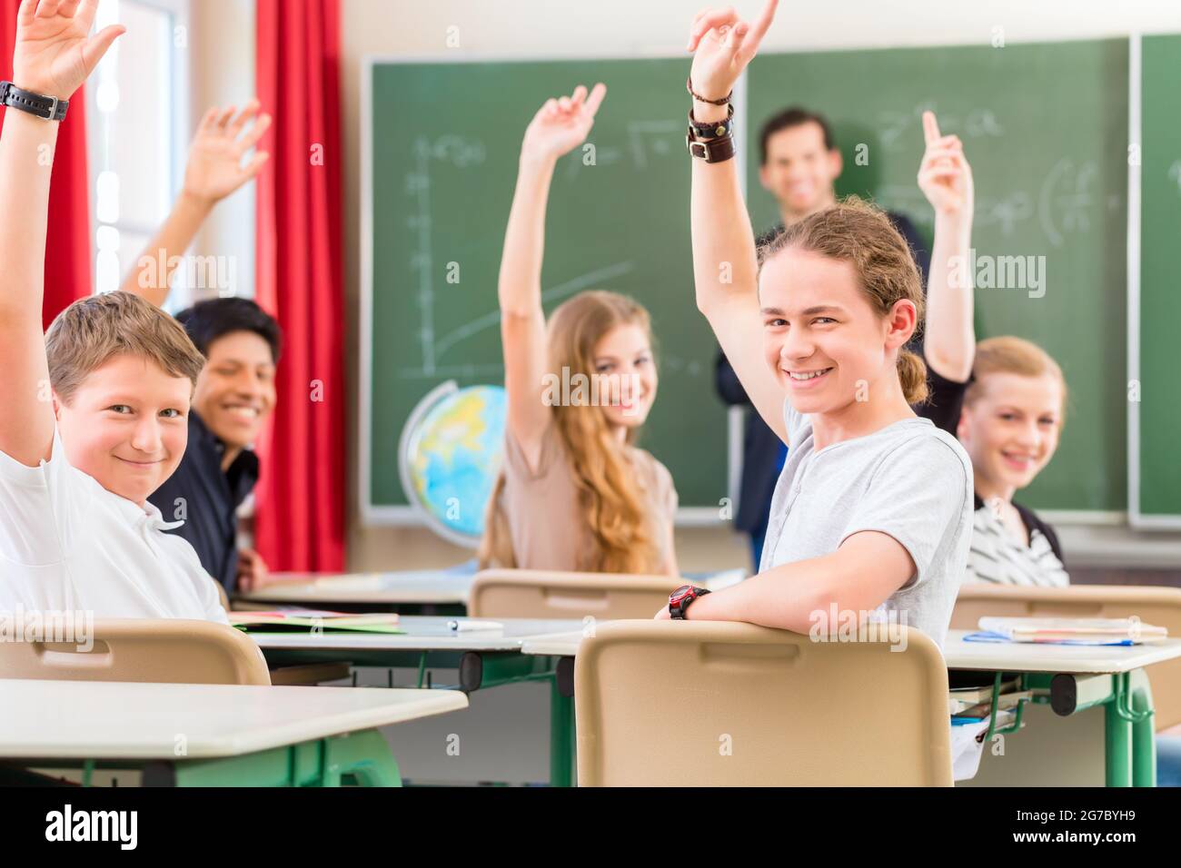 School class teacher giving lesson in front of a blackboard or board ...
