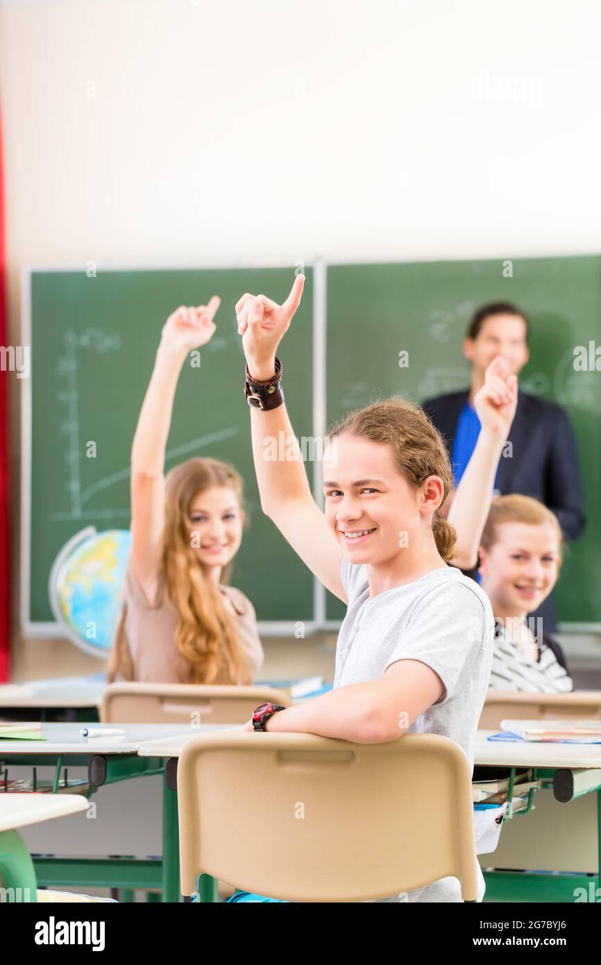 School class teacher giving lesson in front of a blackboard or board ...