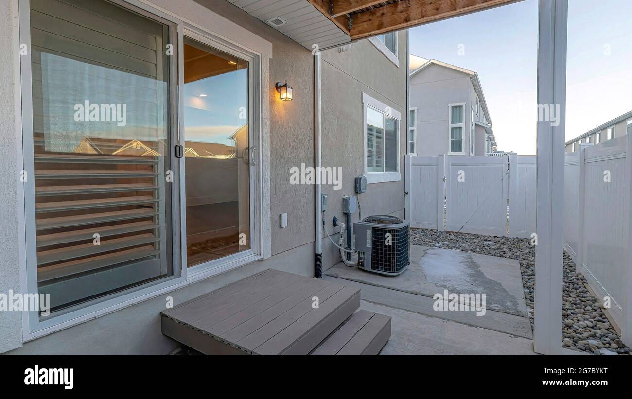 Pano Sliding glass door and wooden steps at the back of a home with ...