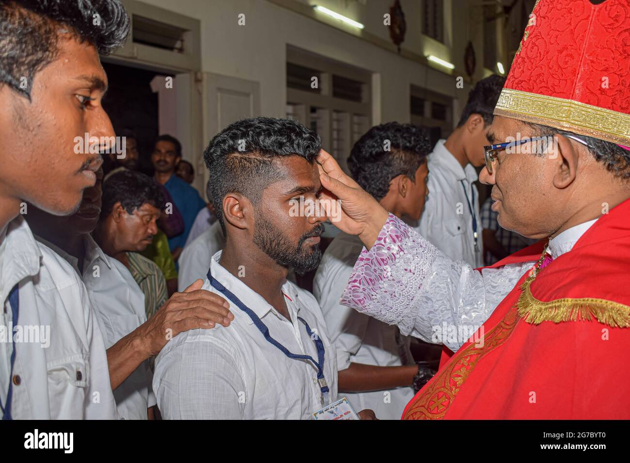 Bishop is giving confirmation sacrament to young teenagers Stock Photo ...