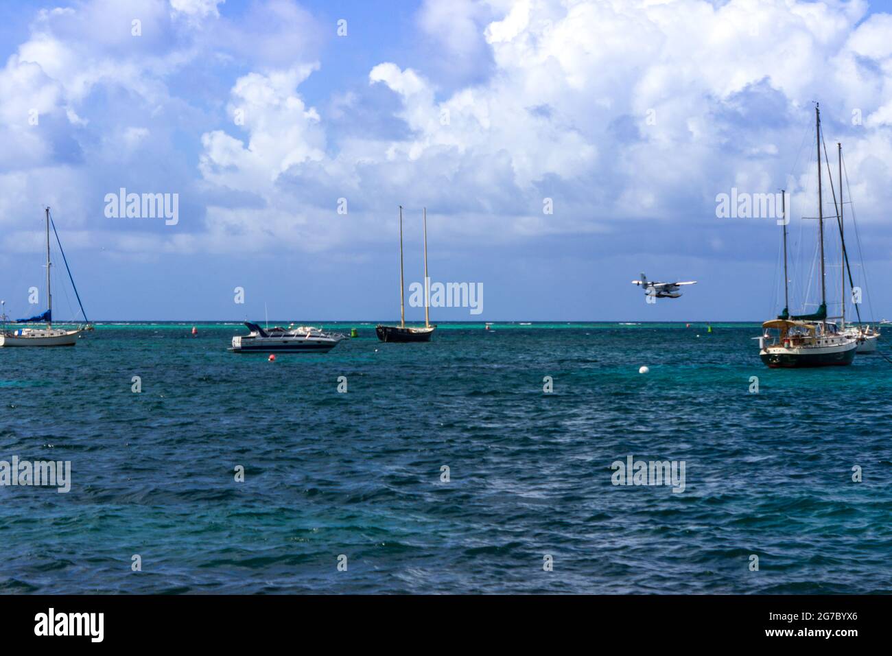 A seaplane takes off from the boat filled harbor at Christiansted, St ...