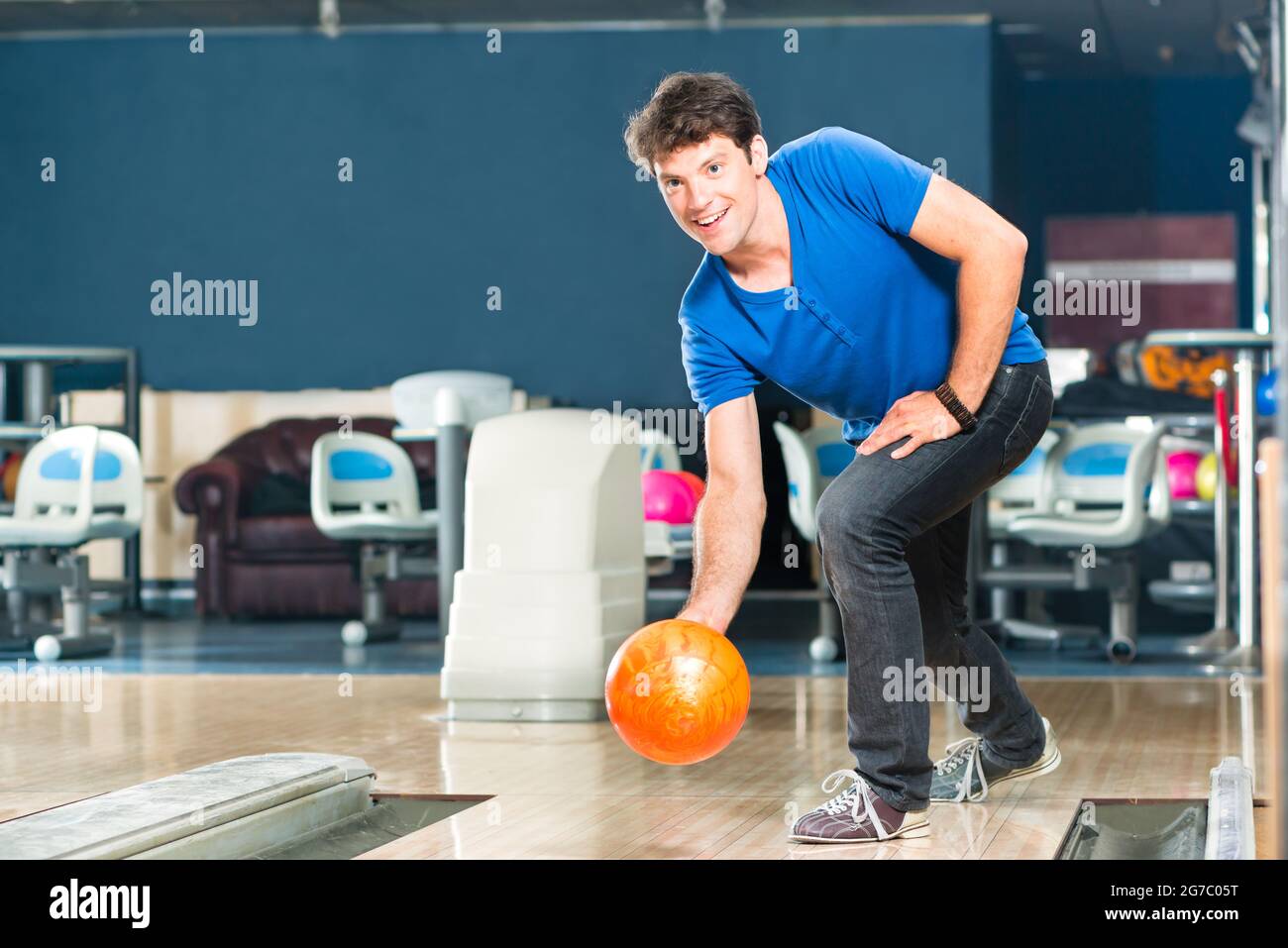 Young man in bowling alley having fun, the sporty man playing a bowling ...