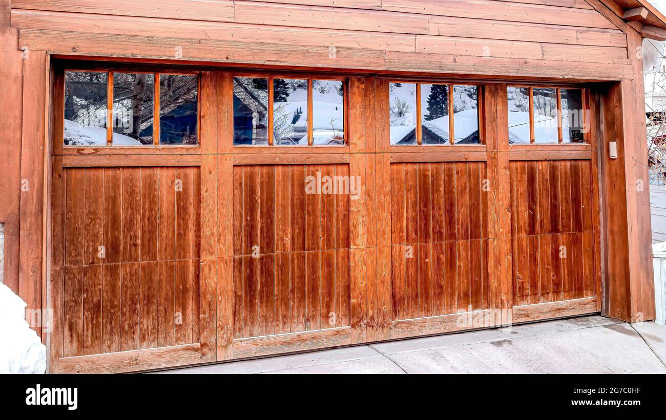 Pano Garage exterior with snowy gable roof over glass paned door and ...