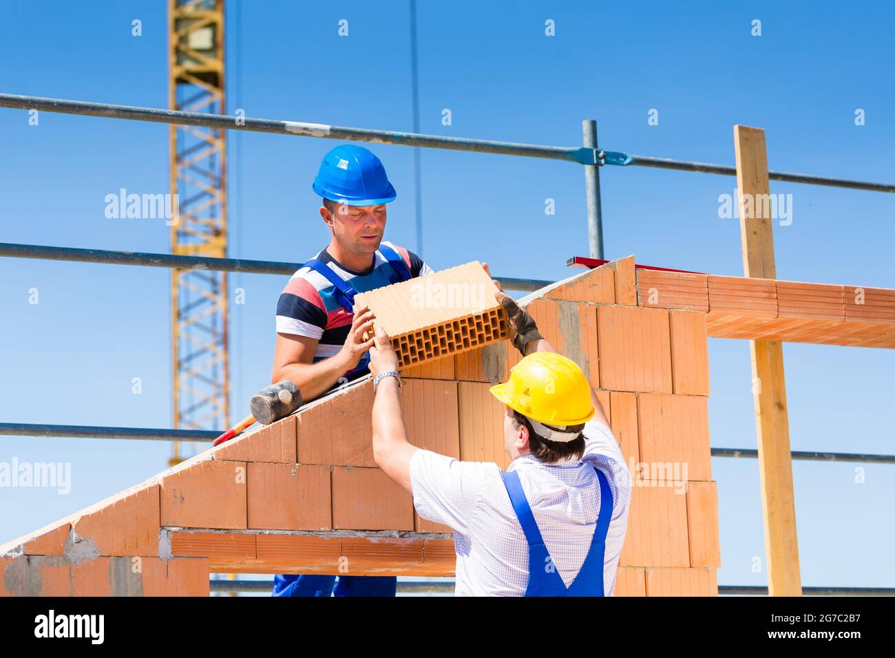 Two Bricklayer or builder or worker build or bricklaying or laying a ...