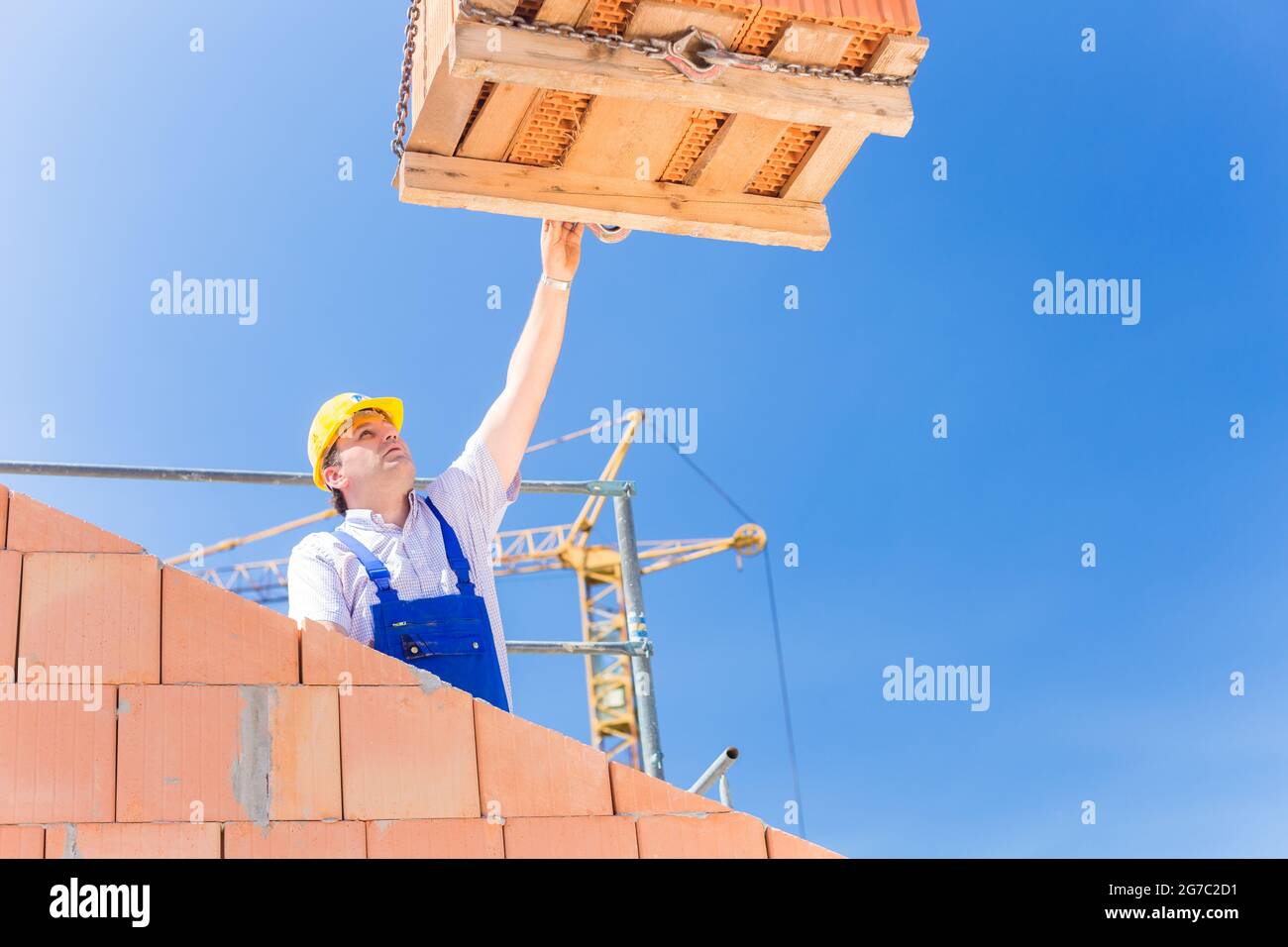 Bricklayer or construction worker getting a delivery with a pallet of ...