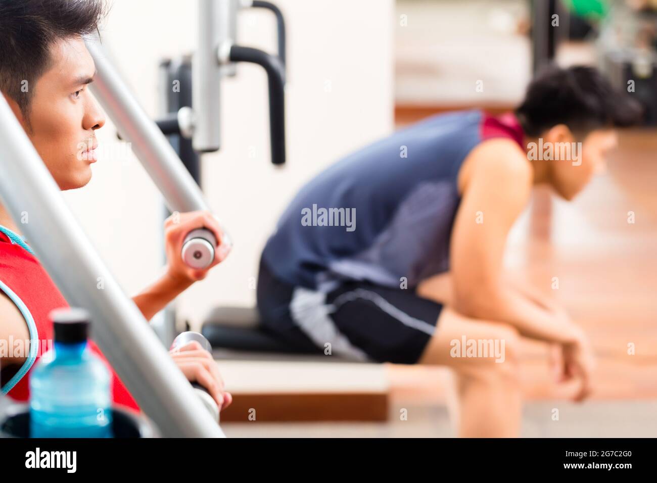 Chinese men having fitness training or workout in gym doing sport to ...