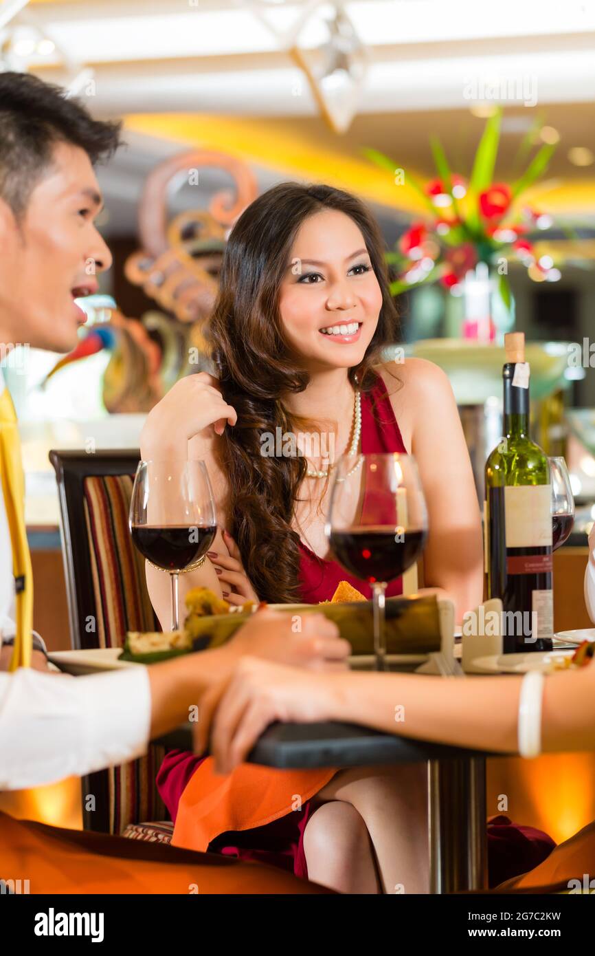 Four Asian Chinese business people having dinner in elegant club ...