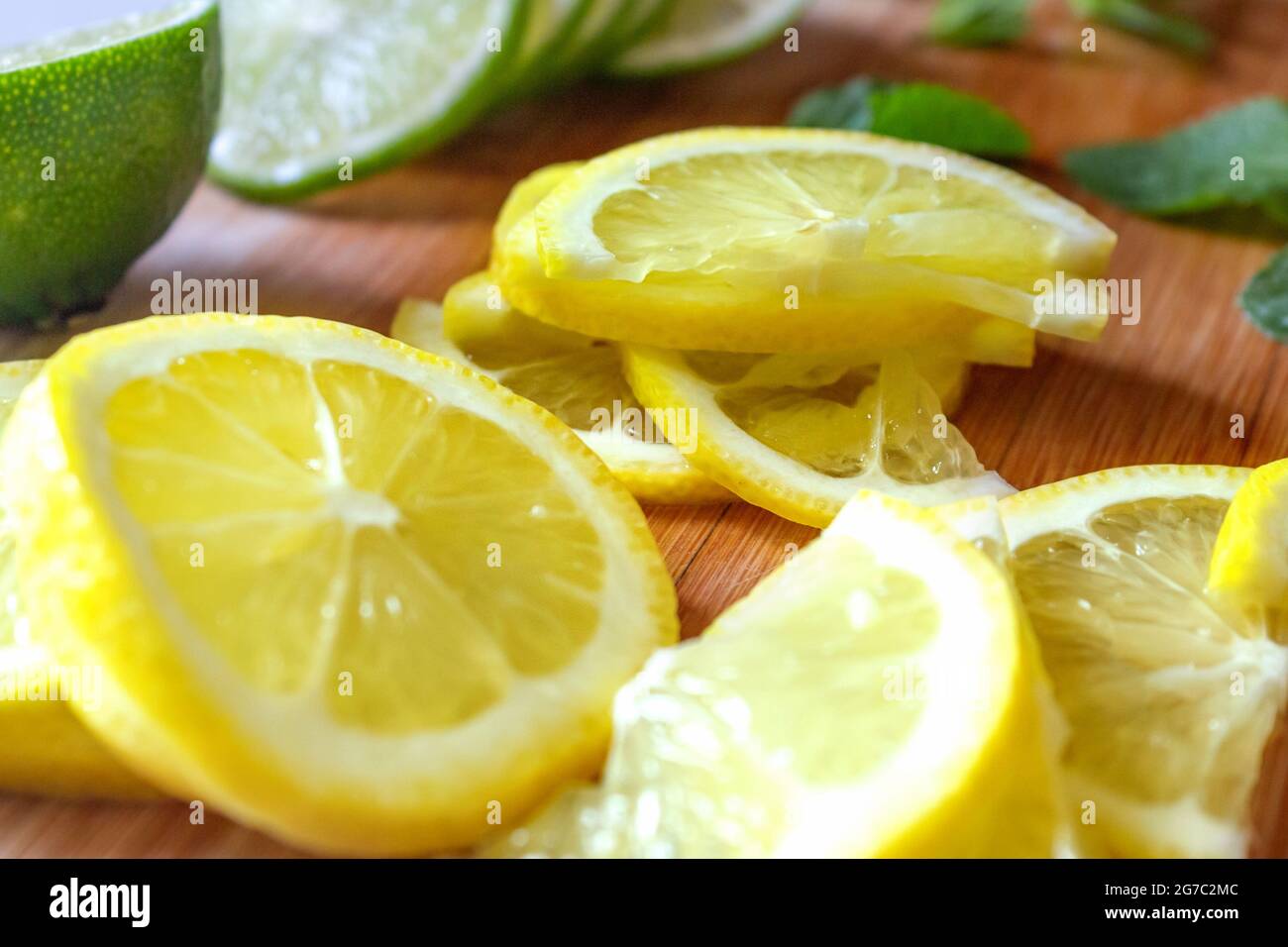 Sliced fresh lemons and lime. Wooden table Stock Photo - Alamy