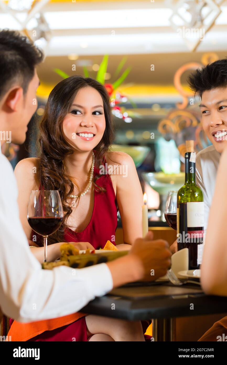 Four Asian Chinese business people having dinner in elegant club ...