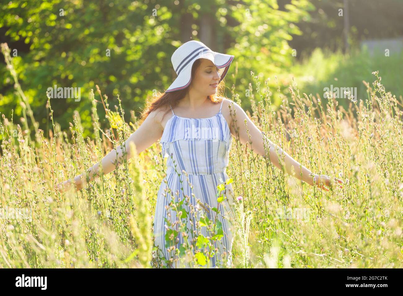 Woman walking in a field in summer sunny day Stock Photo - Alamy