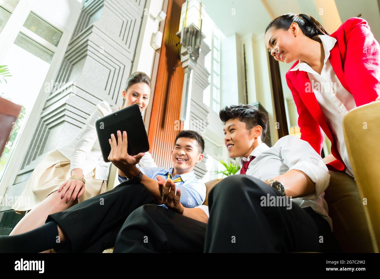 Group of four Asian Chinese businesspeople meeting for small team ...