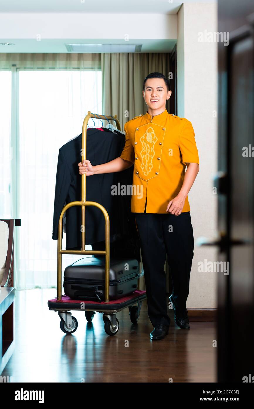 Portrait of bell boy pulling box van Stock Photo - Alamy
