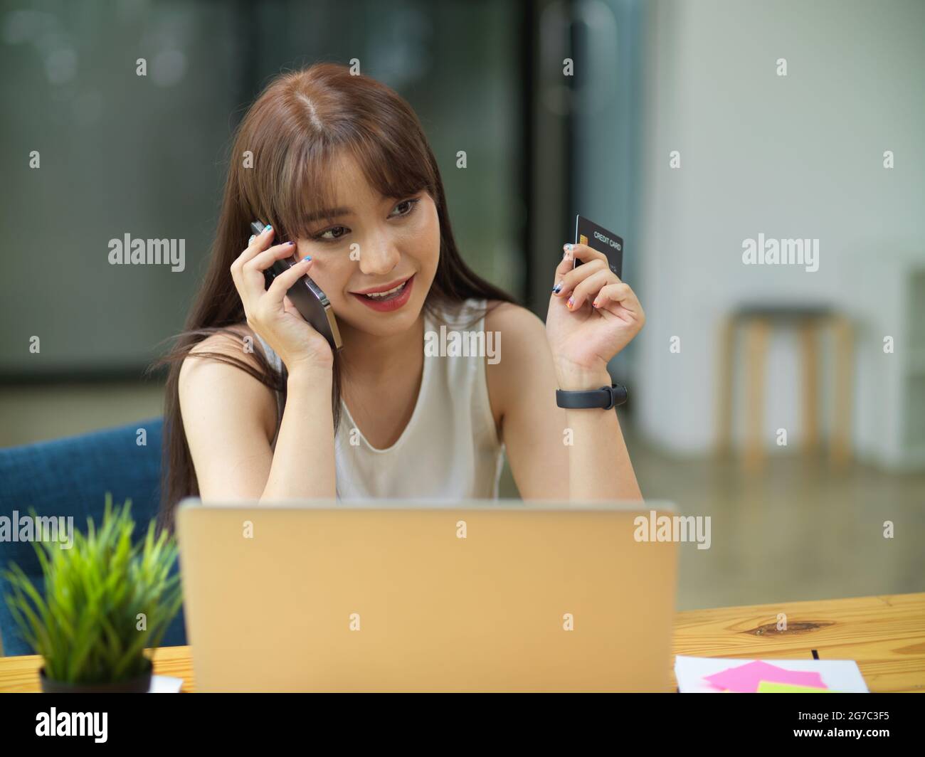 A beautiful young Asian woman using her smartphone in the room. chat ...