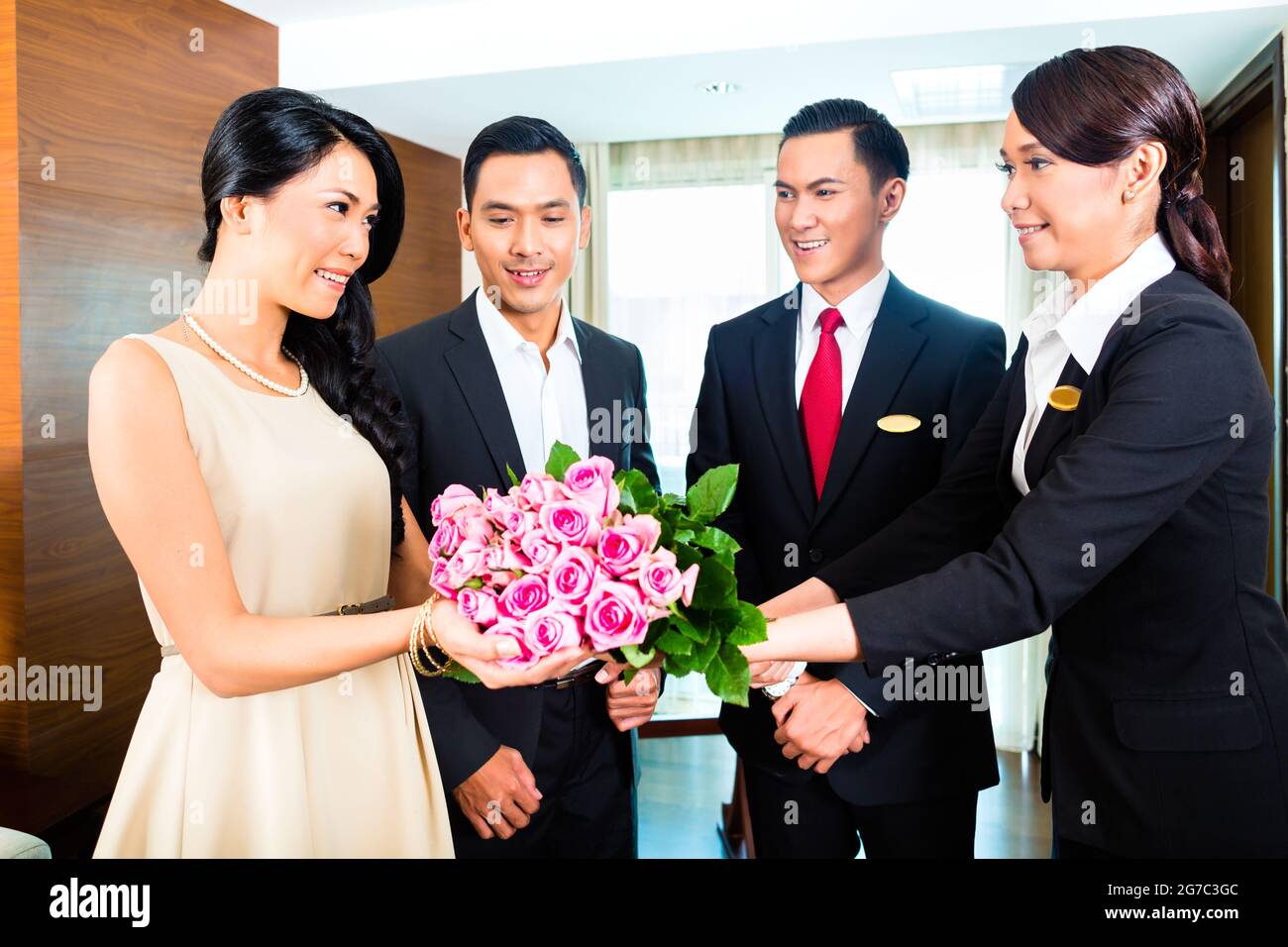 Staff greeting guests in Asian hotel Stock Photo - Alamy