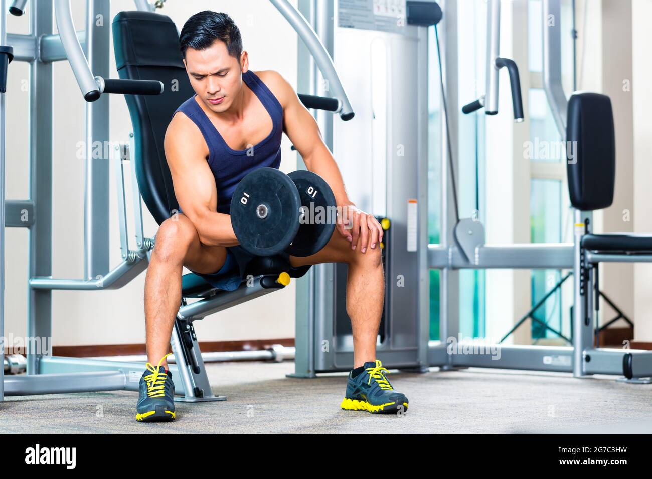 Asian man lifting hand weight at gym Stock Photo - Alamy