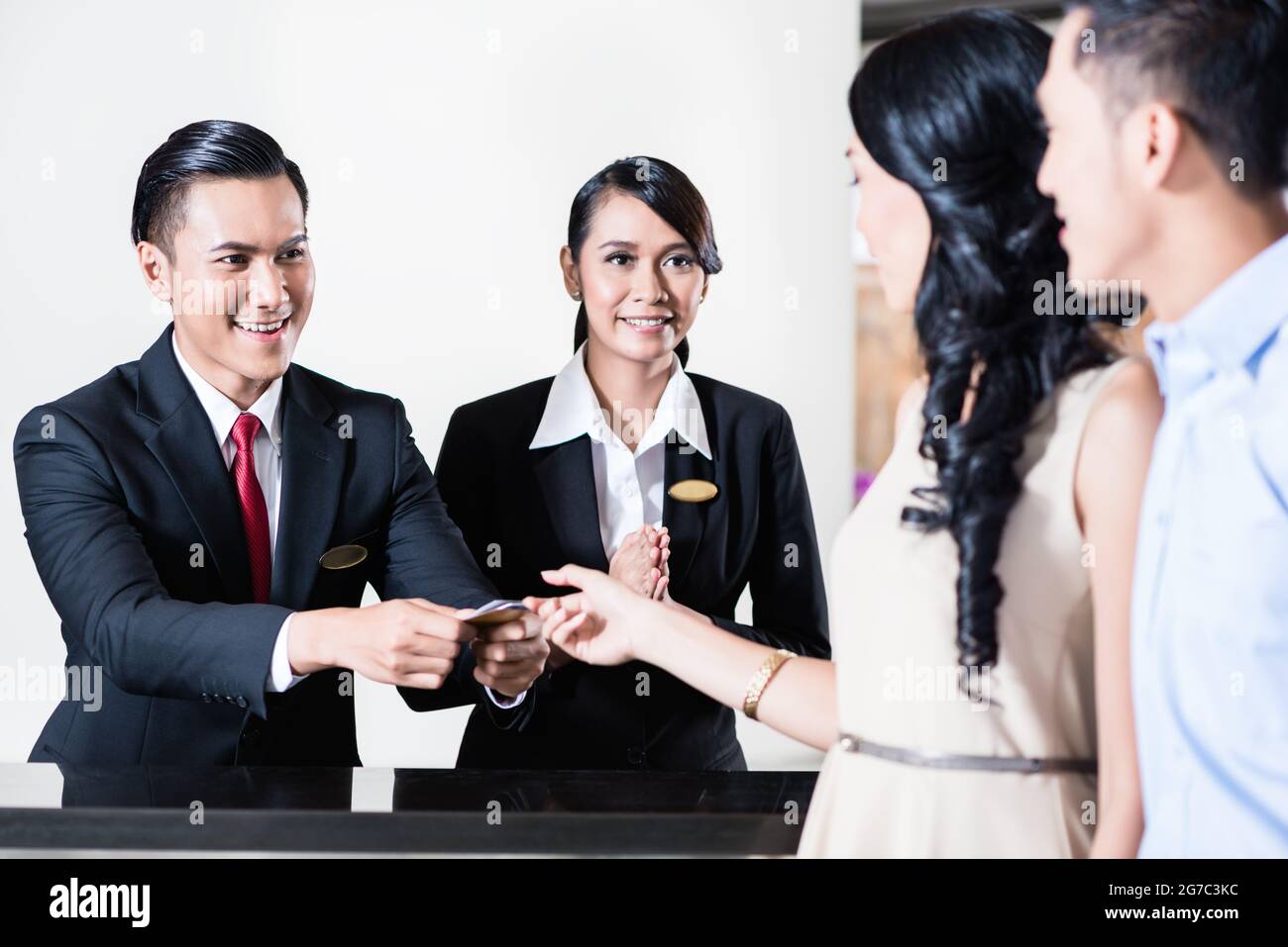 Happy employees are welcoming young couple guest in hotel Stock Photo ...